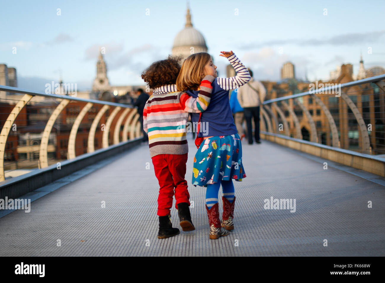 Two friends walk across the Millennium Bridge in London, Britain ...