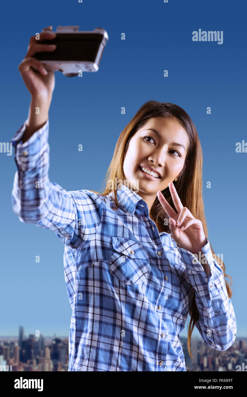 Composite image of smiling asian woman taking picture with camera Stock ...