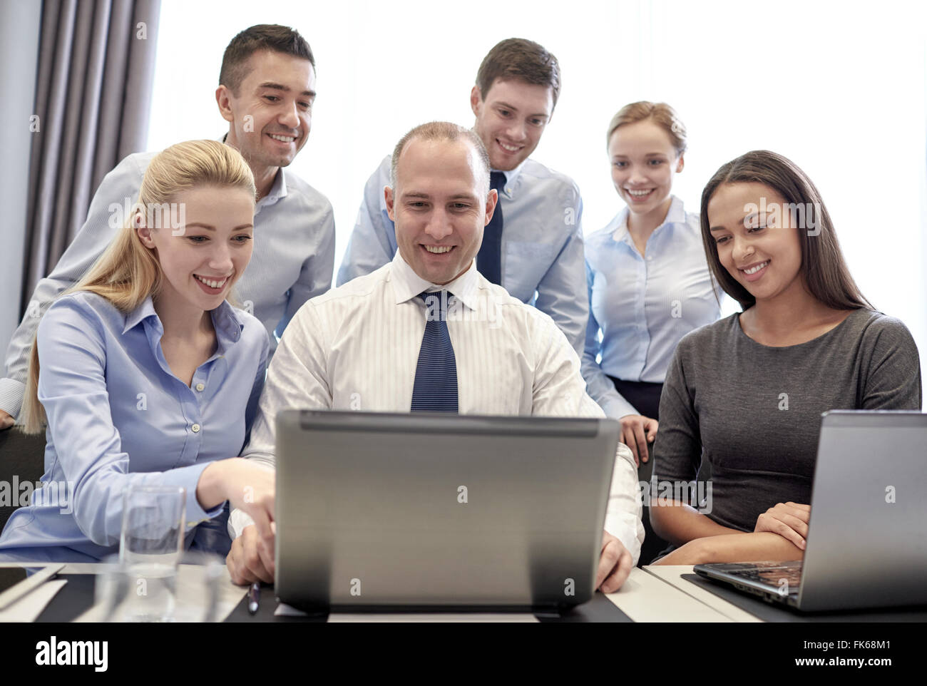 smiling business people with laptop in office Stock Photo - Alamy