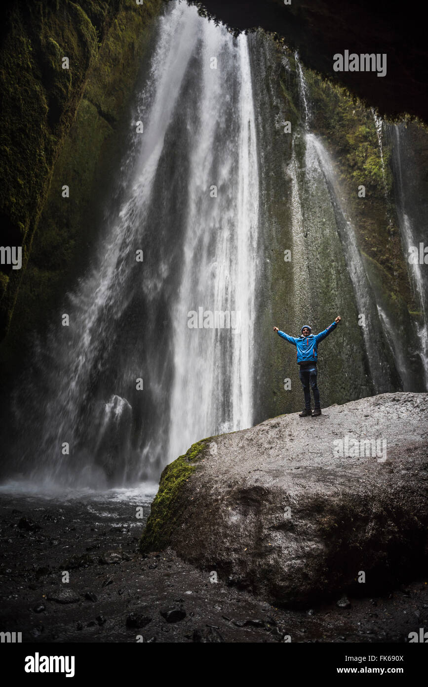 Tourist at the hidden Gljufrabui Waterfall, near Seljalandsfoss, South ...