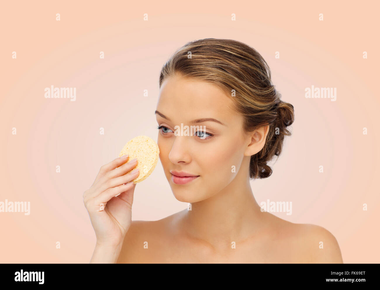 young woman cleaning face with exfoliating sponge Stock Photo - Alamy