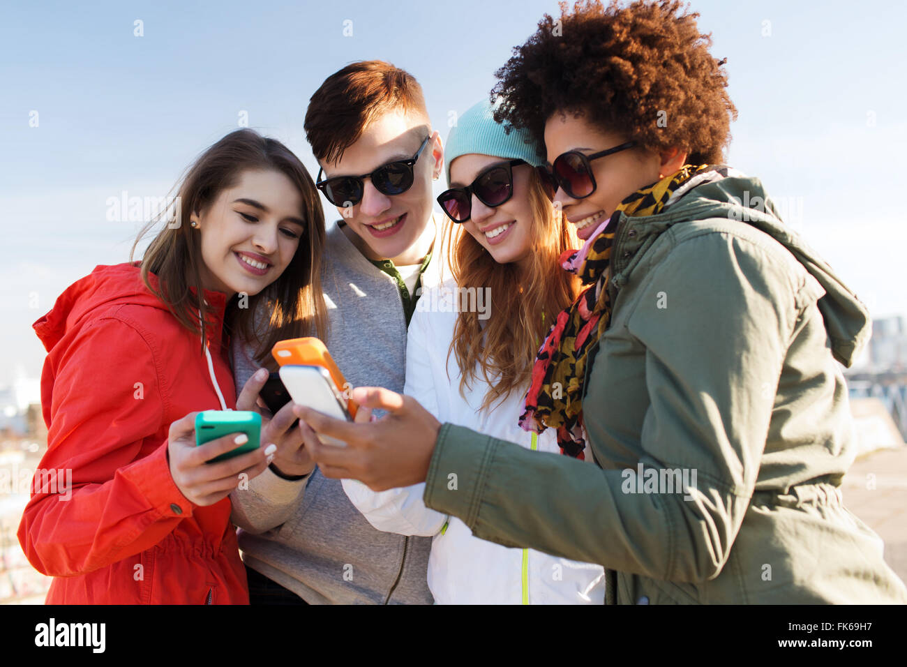 smiling friends with smartphones Stock Photo - Alamy