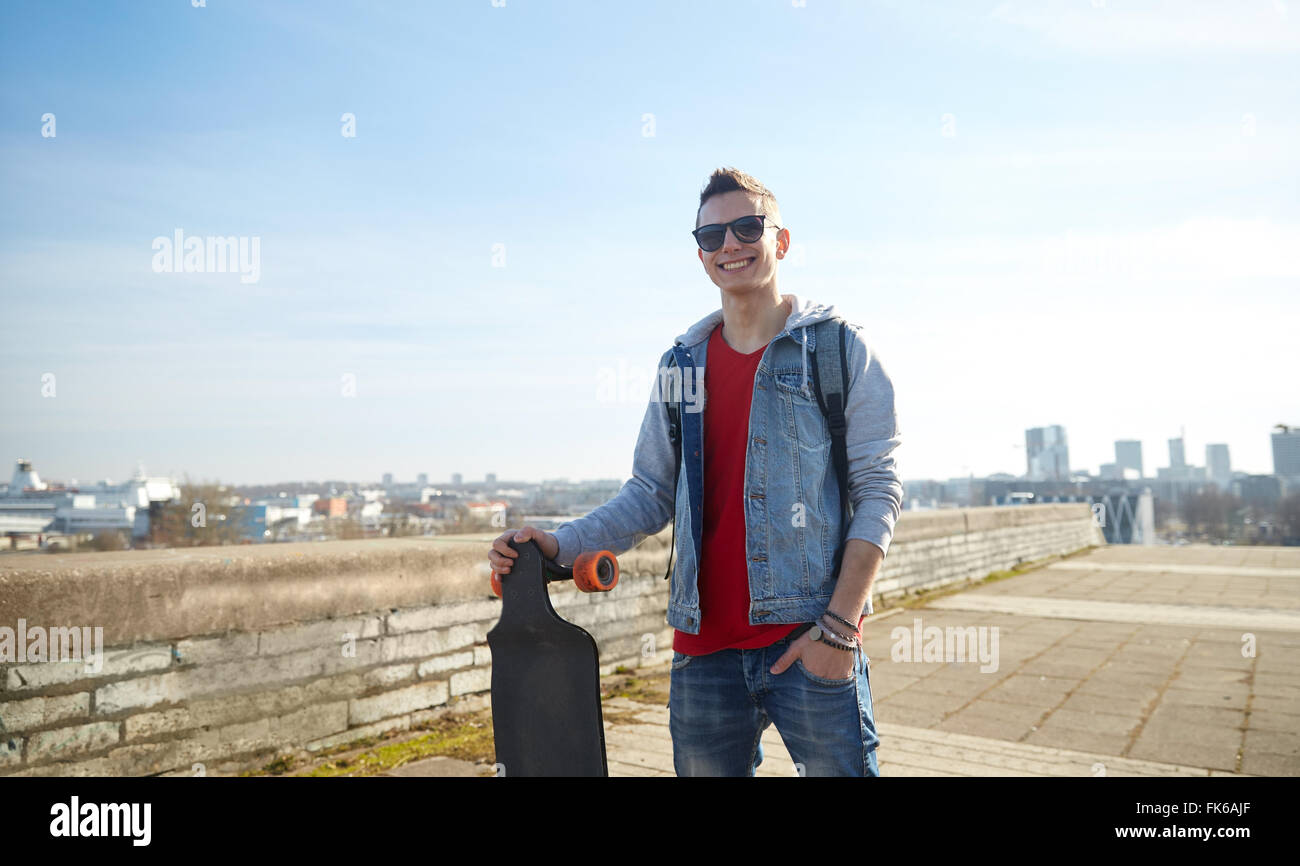 smiling teenager with longboard on street Stock Photo - Alamy