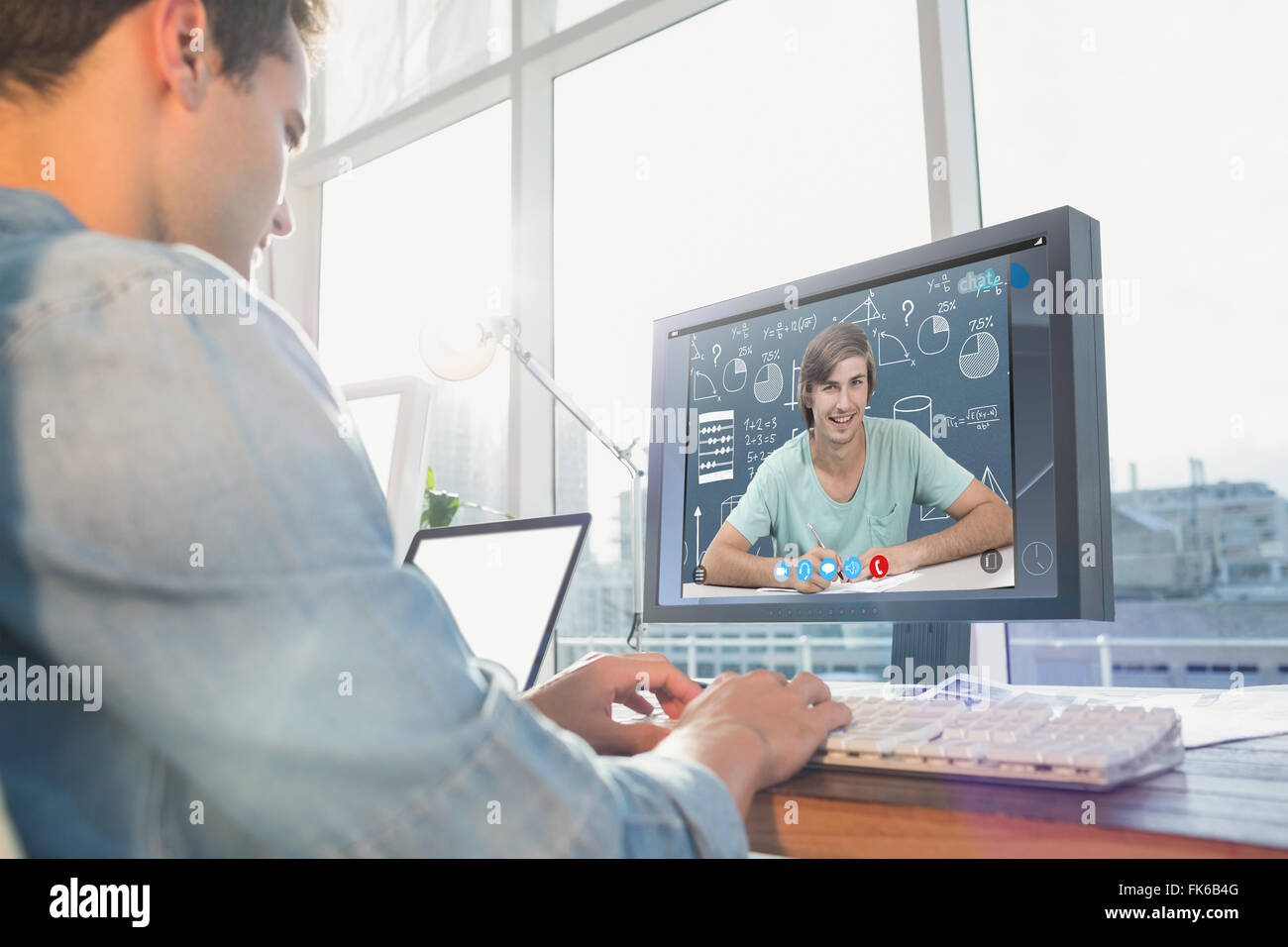 Composite image of businessman using computer at desk in creative ...