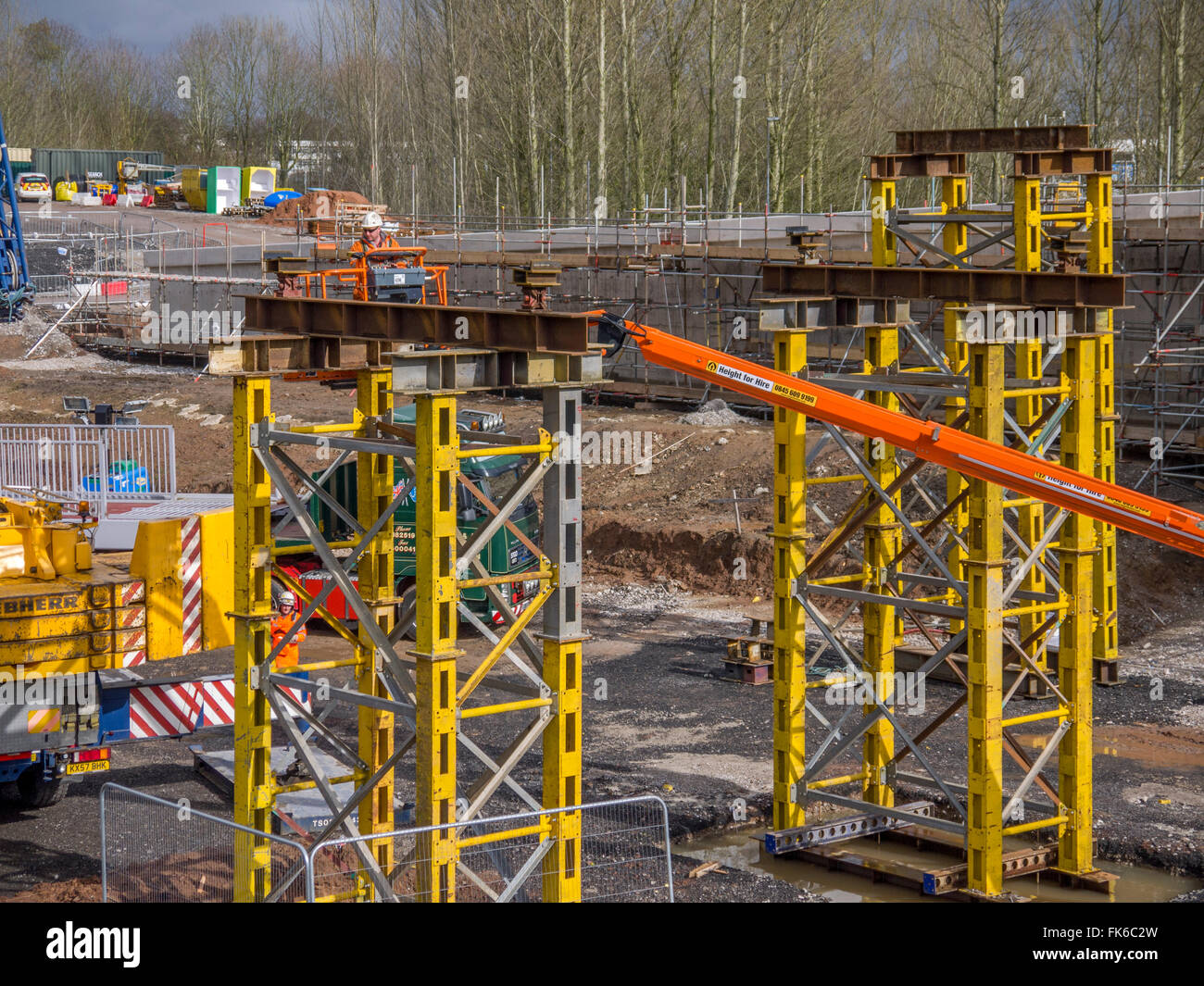 Construction worker on hydraulic lift, checking stilts are in place for ...