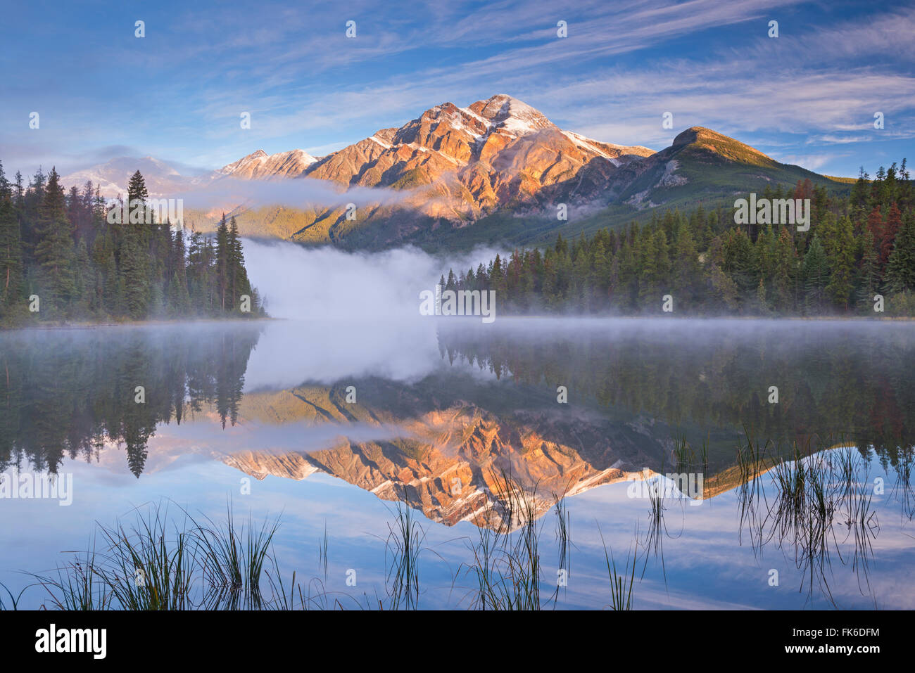 Pyramid Mountain reflected in Pyramid Lake at dawn on a misty morning ...