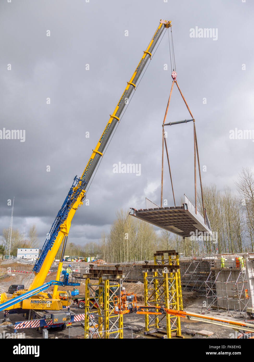 Crane lifting a section of a footbridge in to place, with construction ...