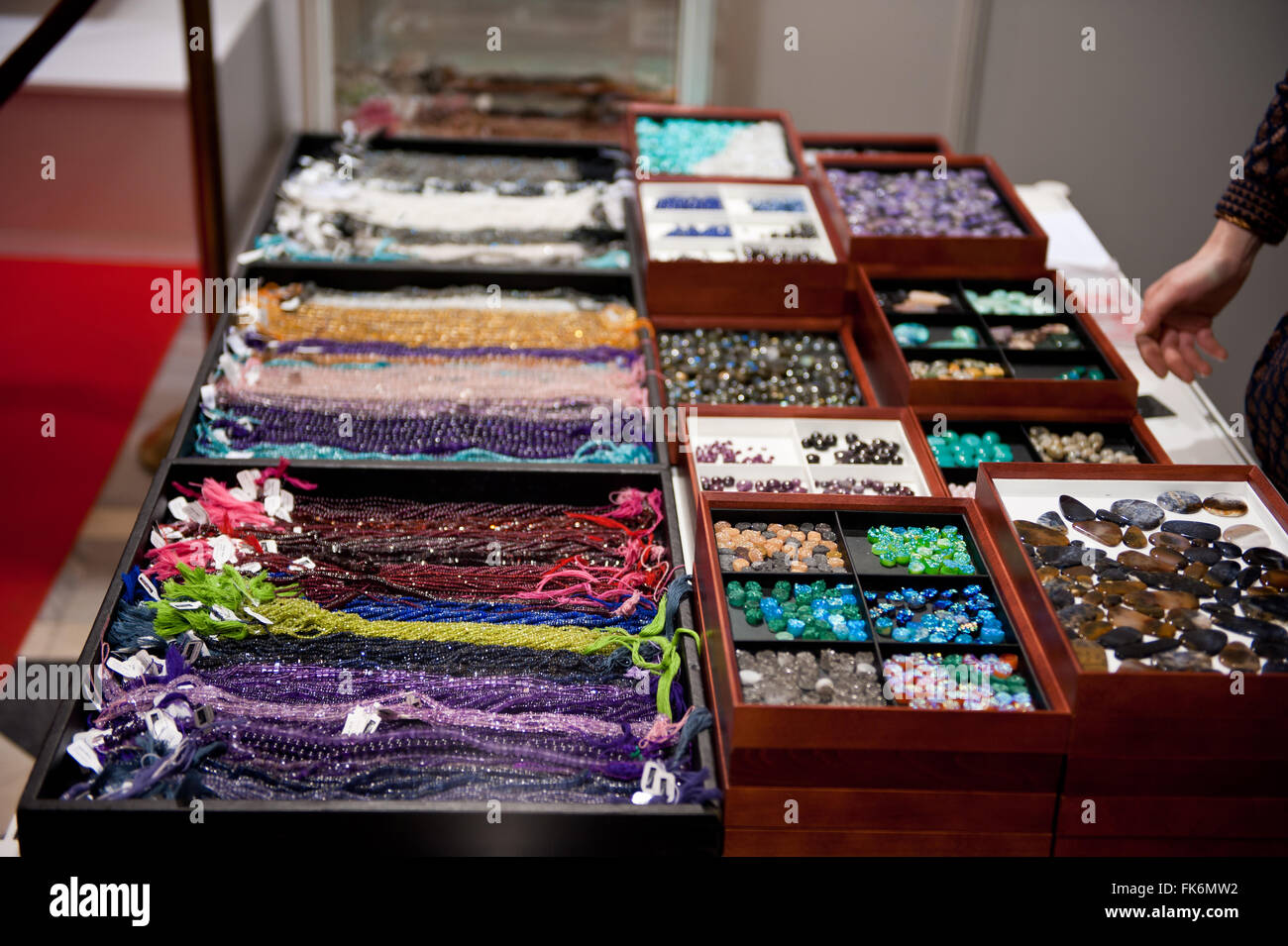Woman choosing colored beads, stand at the Warsaw Mineral Expo 2016 ...