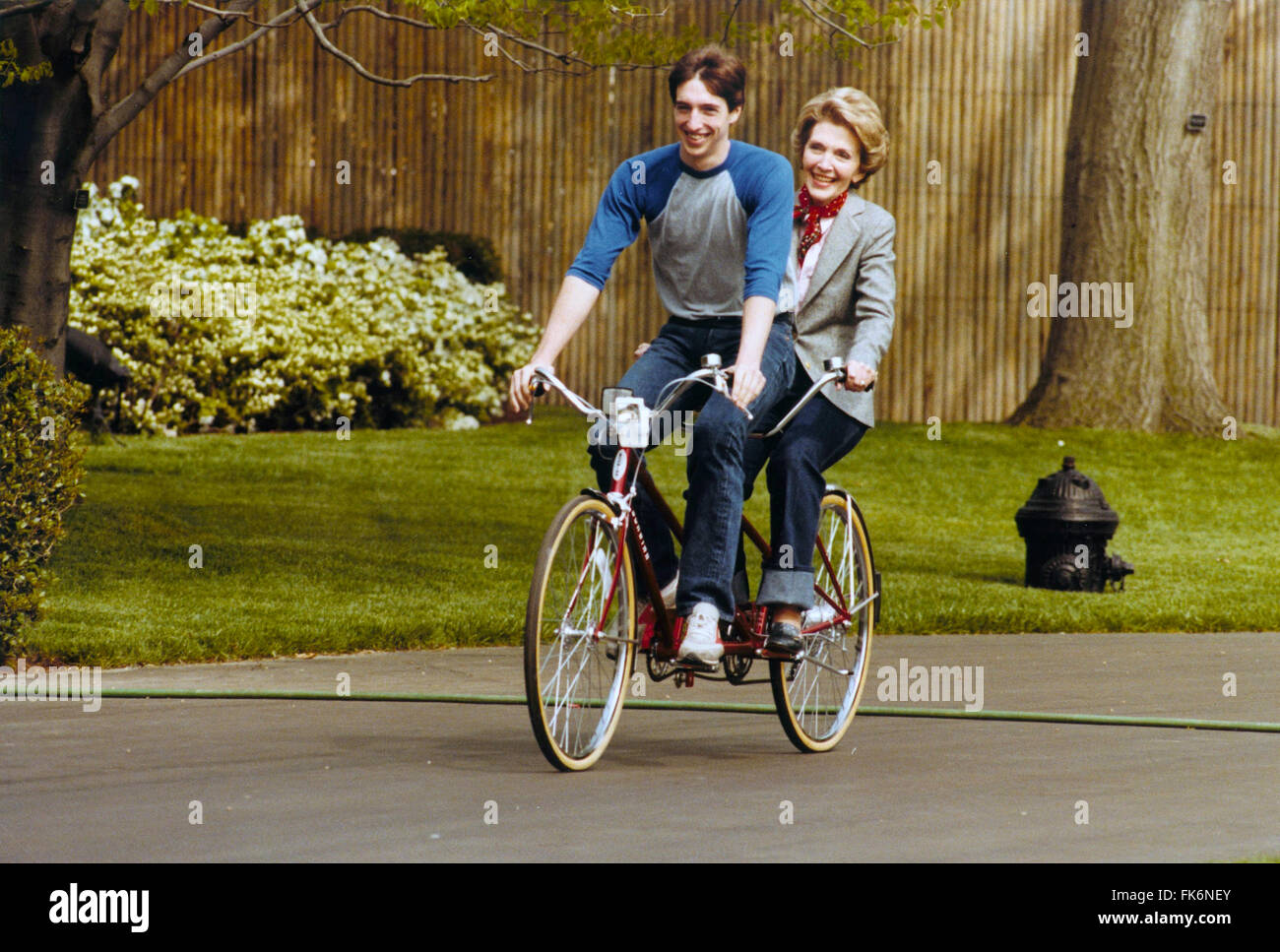 First Lady Nancy Reagan riding a tandem bicycle with son Ron Reagan on ...