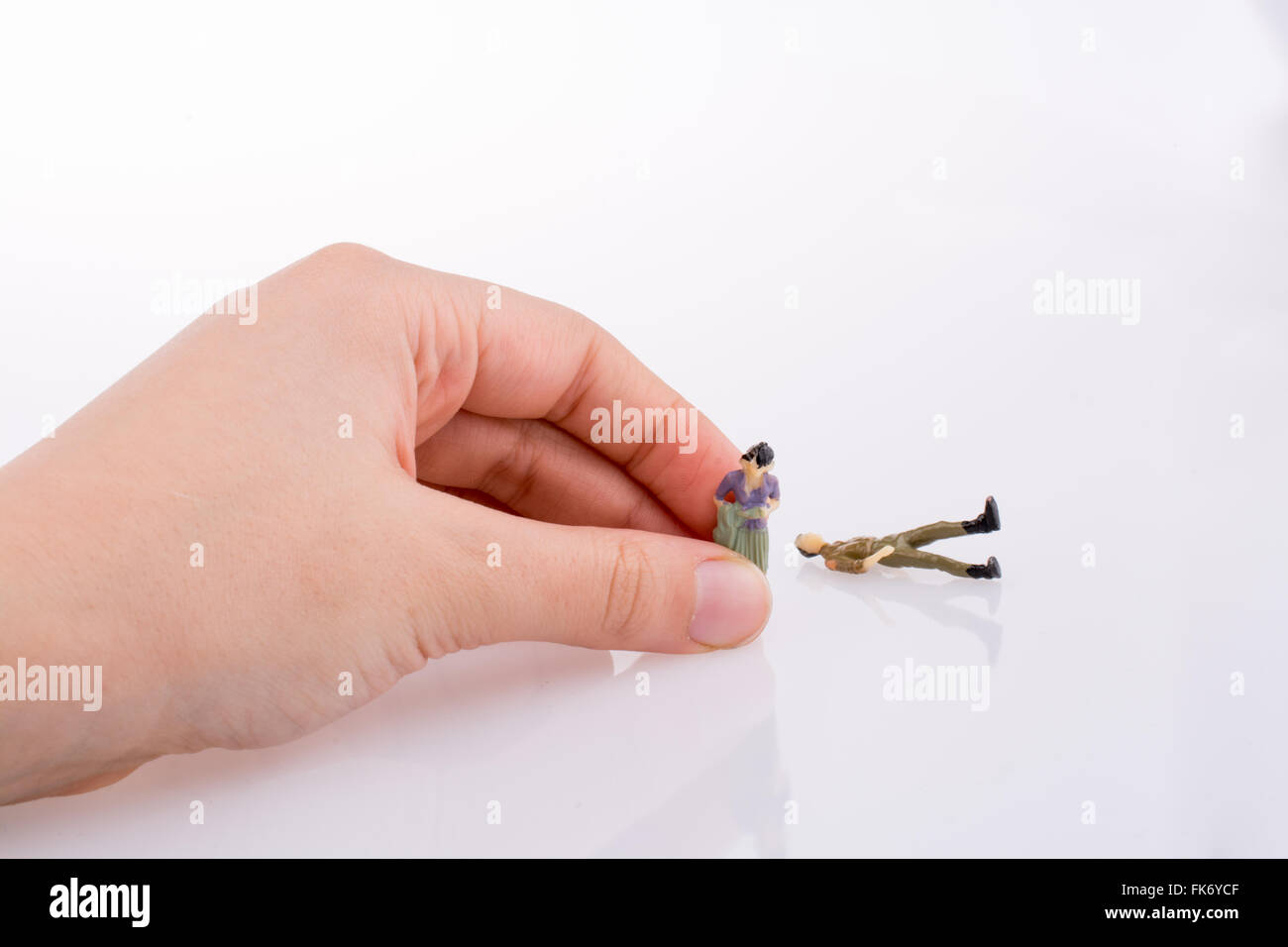 Hand holding human figure on a white background Stock Photo - Alamy