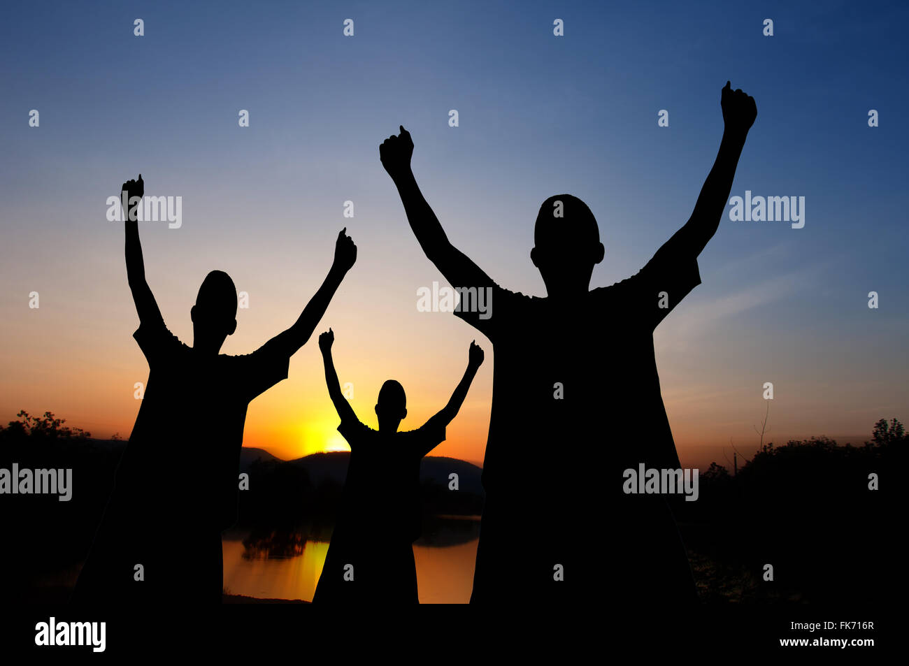 silhouette of man happy and victory together at the lake with sundown ...
