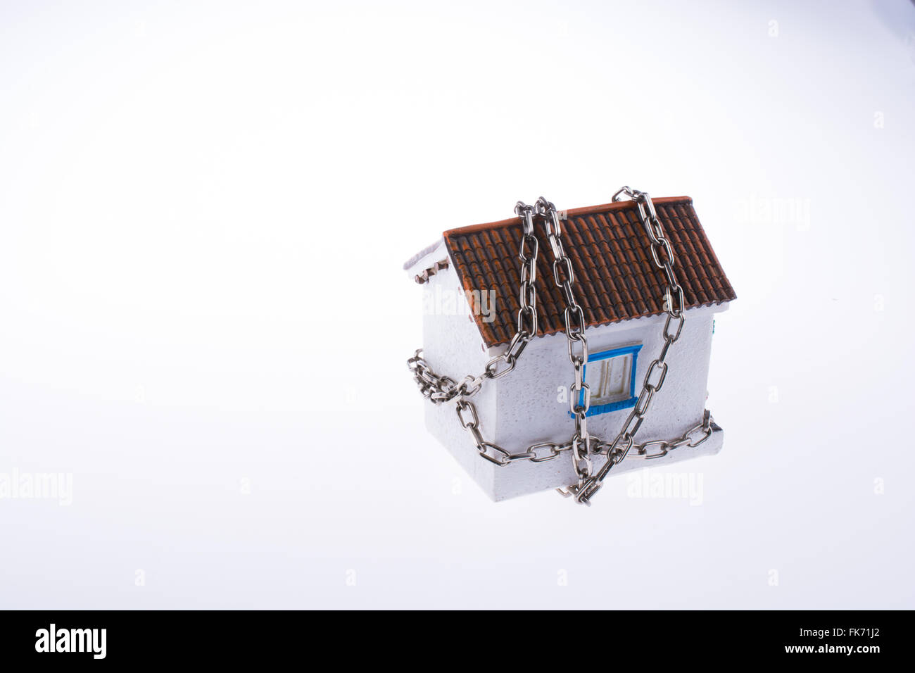 house in chains on a white background Stock Photo - Alamy
