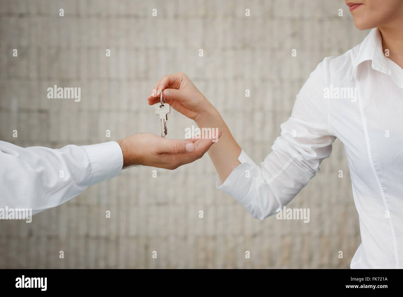 Man and woman hand passing keys in office Stock Photo - Alamy