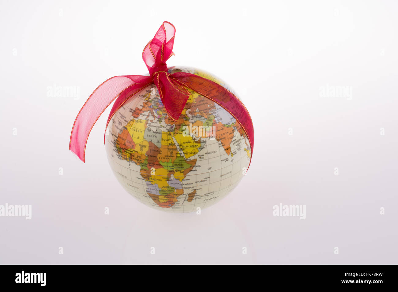 Globe tied with red ribbon on a white background Stock Photo - Alamy