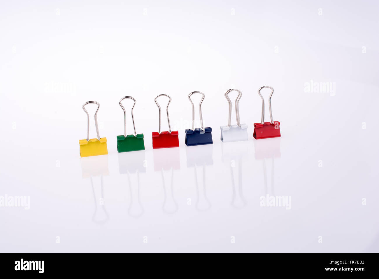 Colored paper clips on a white background Stock Photo - Alamy