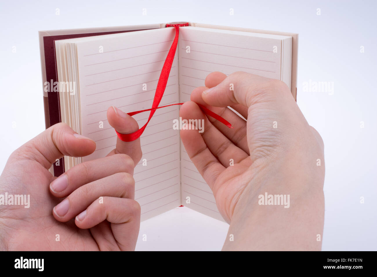 Hand holding a notebook on a white background Stock Photo - Alamy