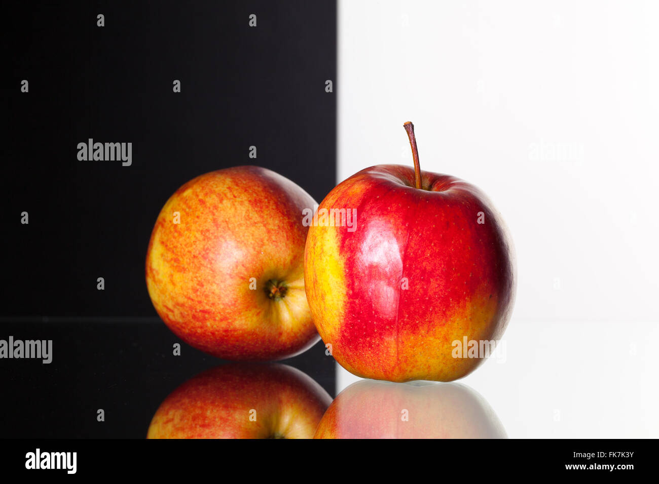 Two apples isolated on black and white background and glass desk Stock ...