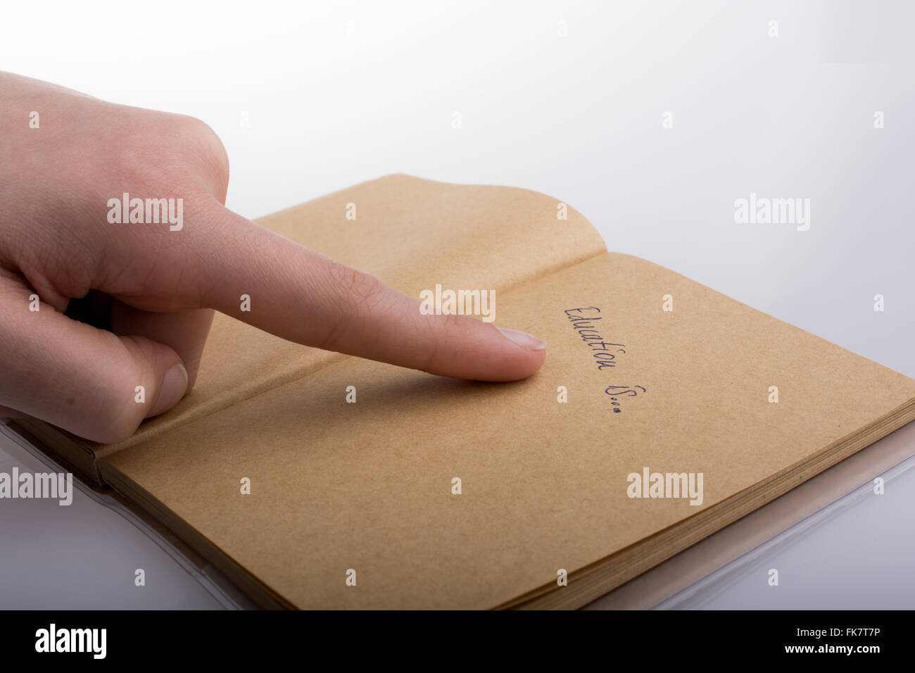 Hand pointing 'Education is...' on a notebook Stock Photo - Alamy