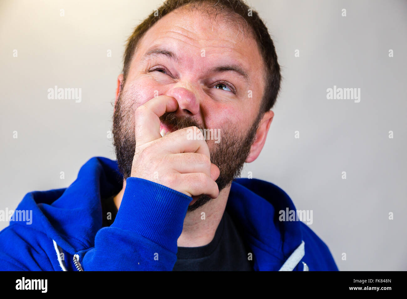 Man in his mid-30's poses for a studio portrait with a semi white ...