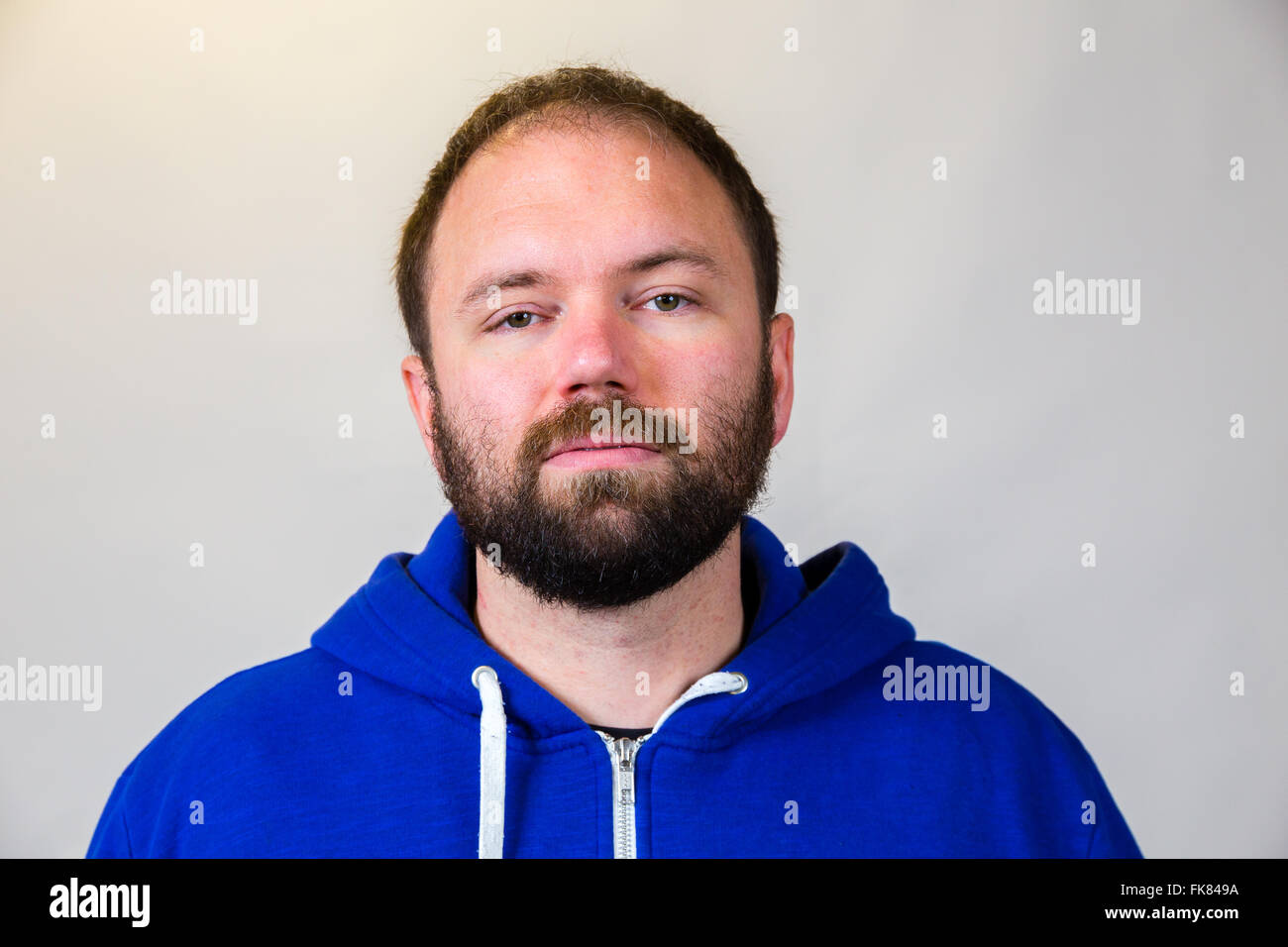 Man in his mid-30's poses for a studio portrait with a semi white ...