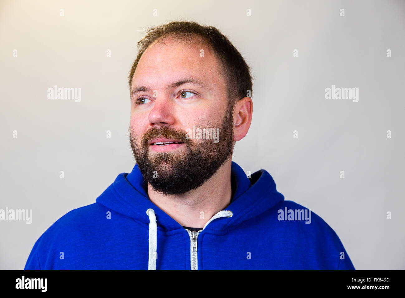Man in his mid-30's poses for a studio portrait with a semi white ...