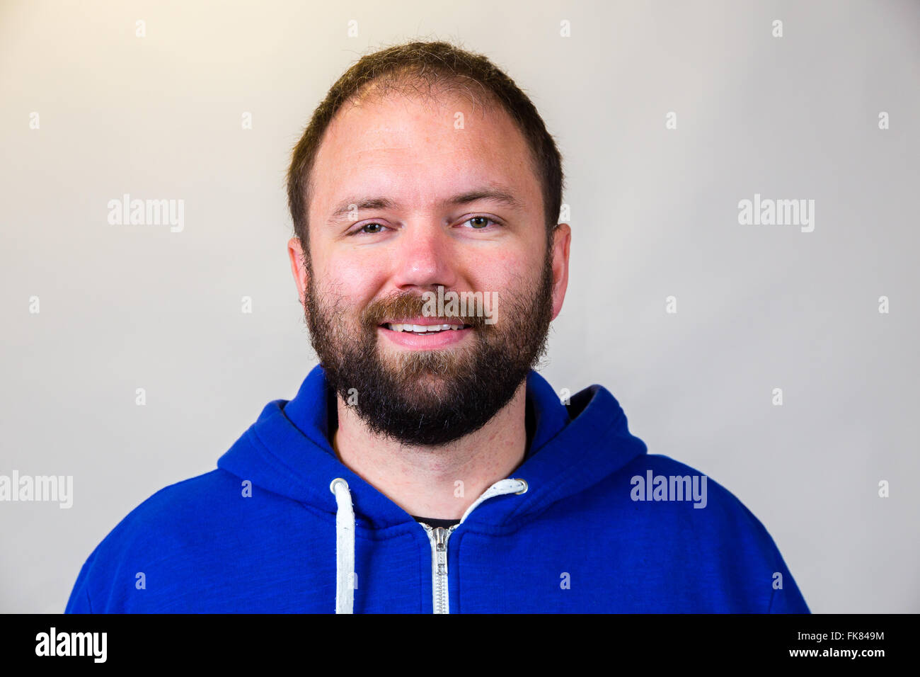 Man in his mid-30's poses for a studio portrait with a semi white ...