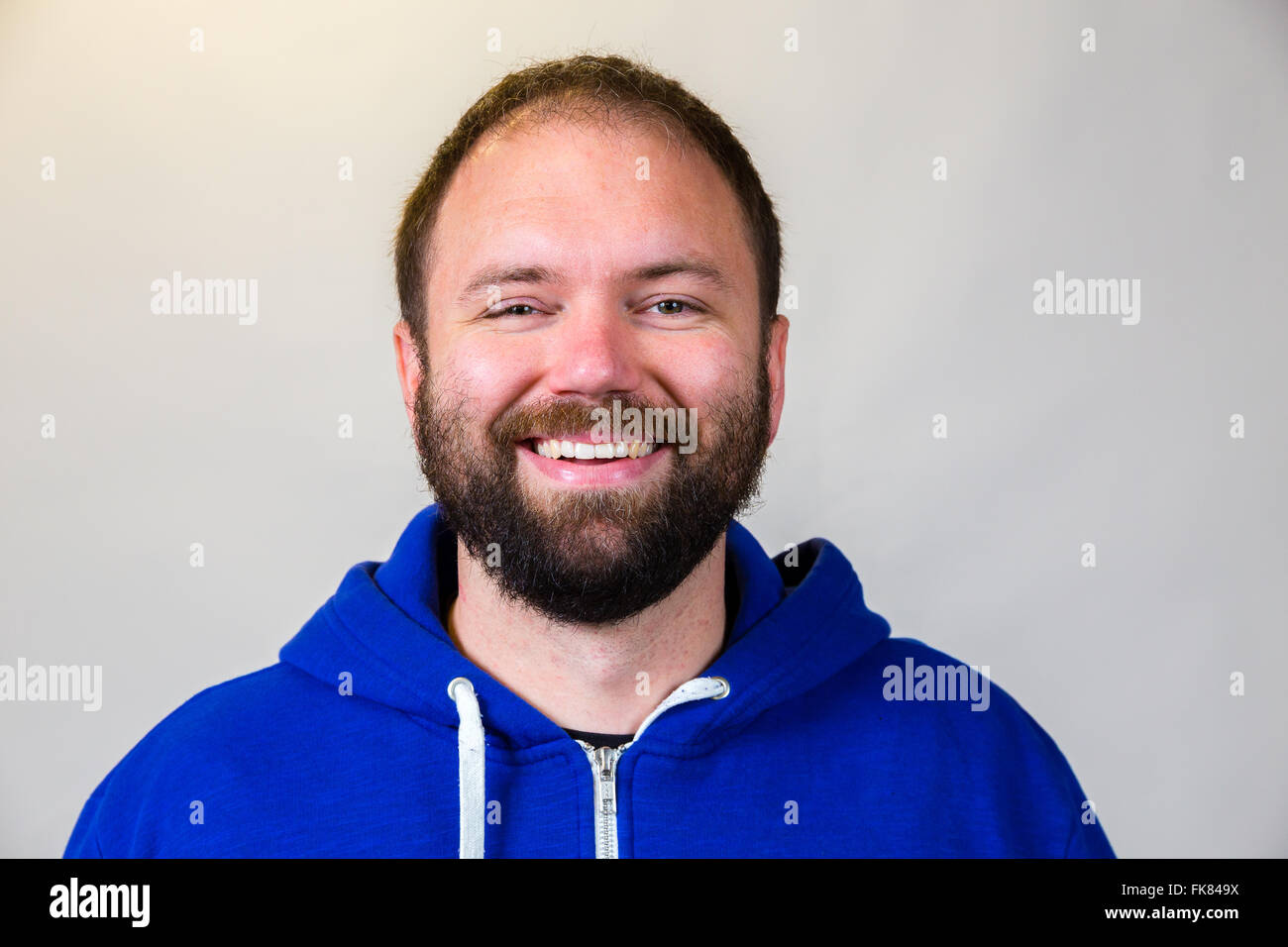 Man in his mid-30's poses for a studio portrait with a semi white ...