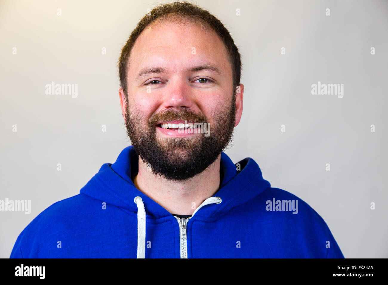 Man in his mid-30's poses for a studio portrait with a semi white ...