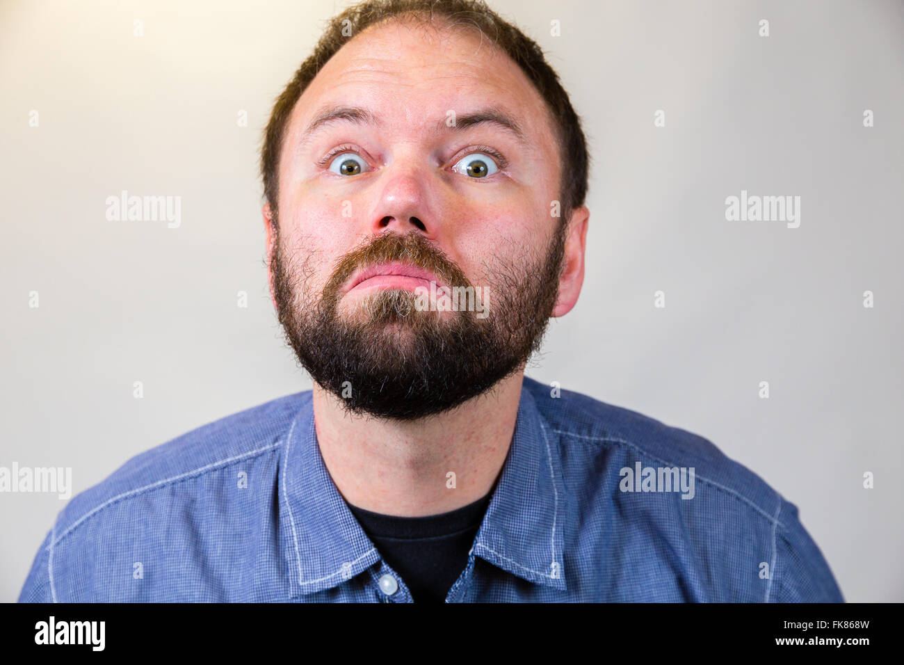 Man in his mid-30's poses for a studio portrait with a semi white ...