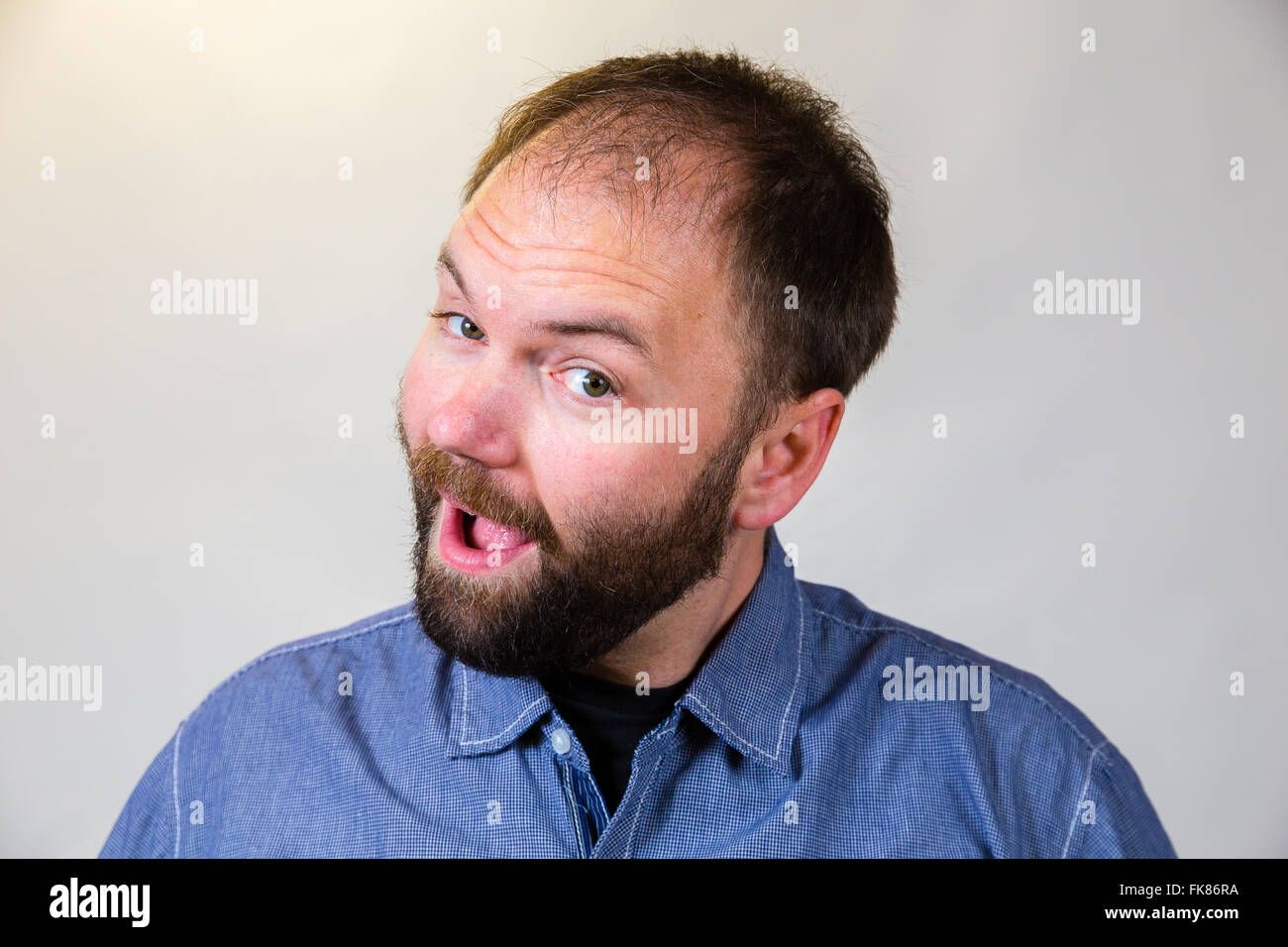 Man in his mid-30's poses for a studio portrait with a semi white ...