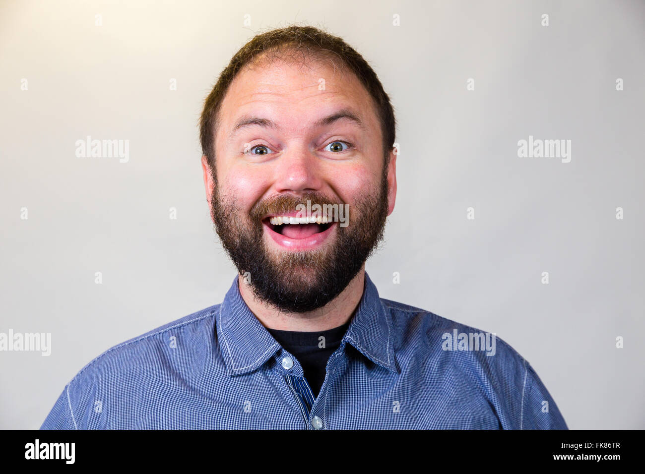Man in his mid-30's poses for a studio portrait with a semi white ...