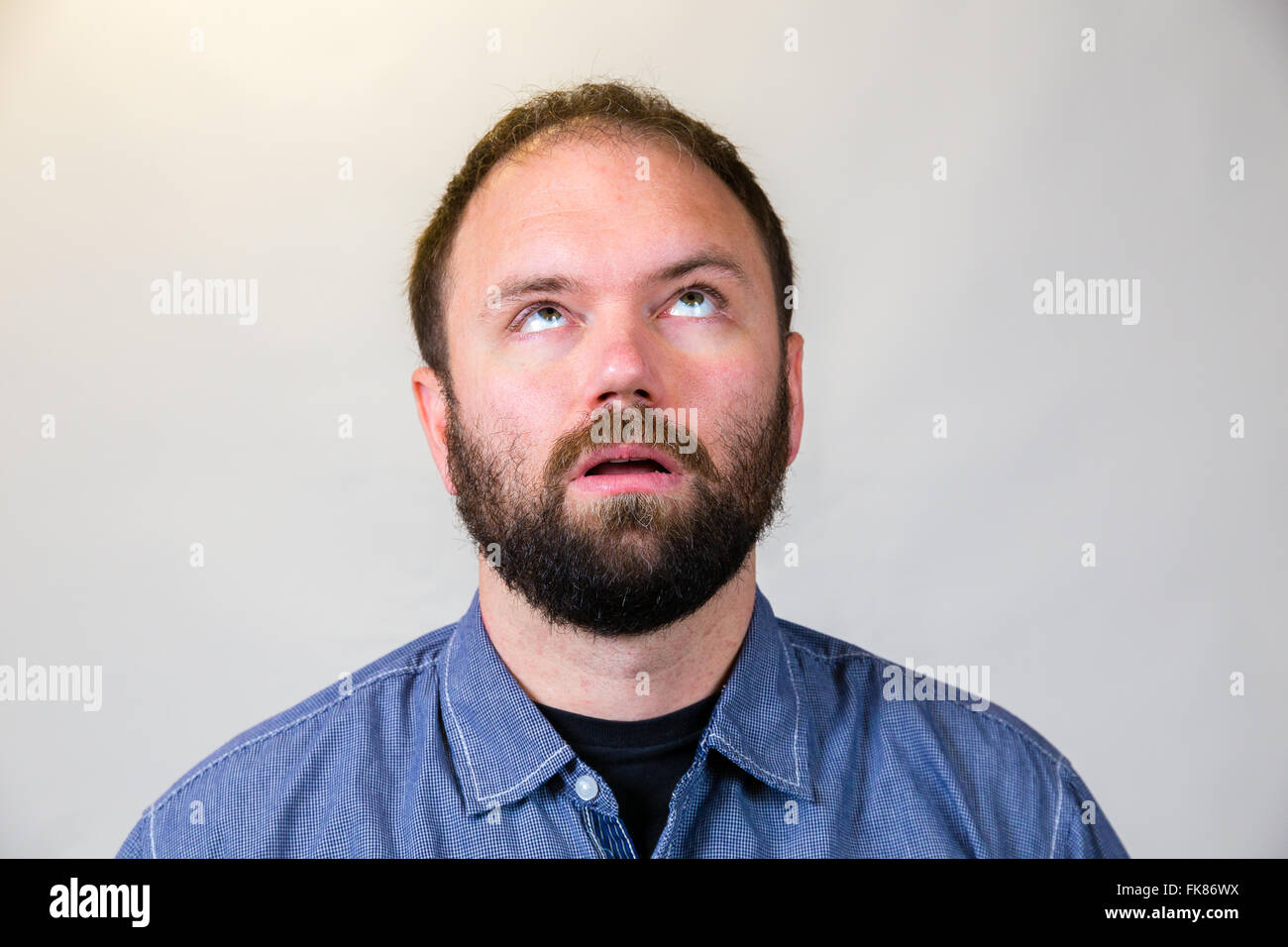 Man in his mid-30's poses for a studio portrait with a semi white ...