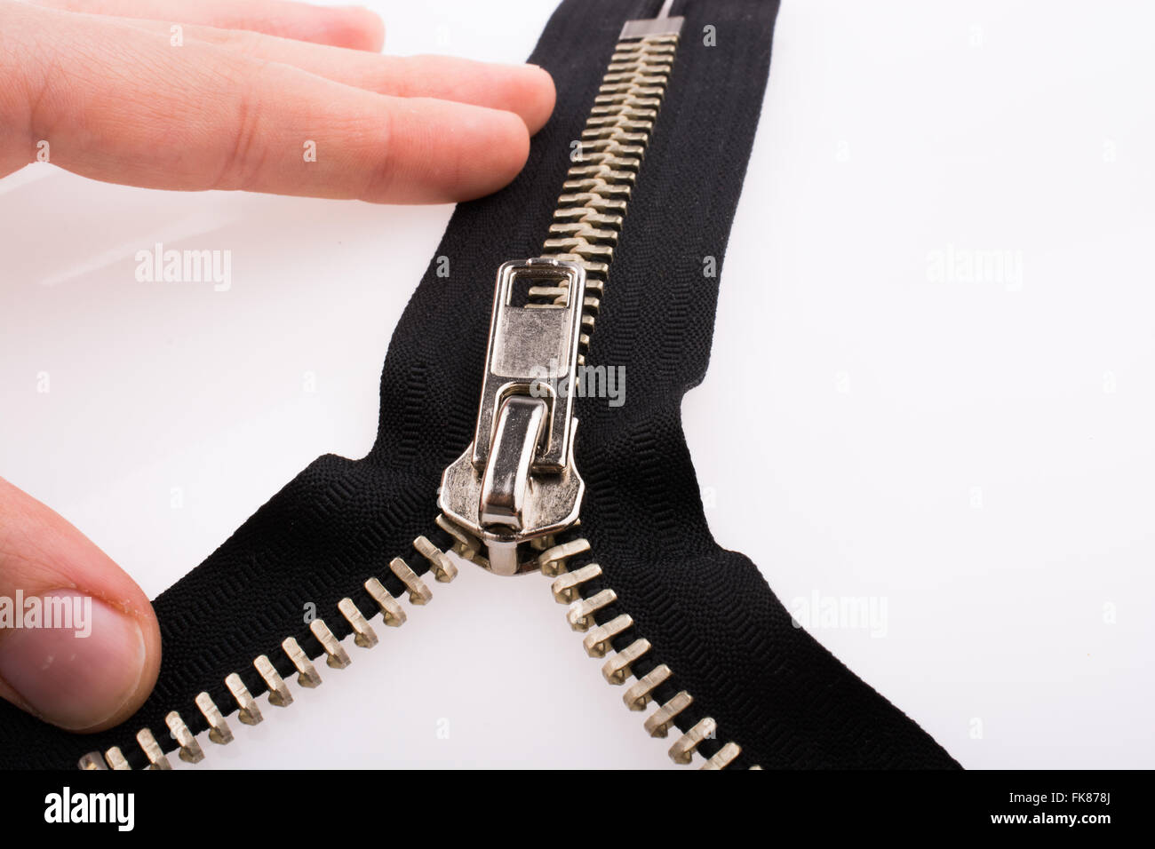 Hand holding color zipper on a white background Stock Photo - Alamy