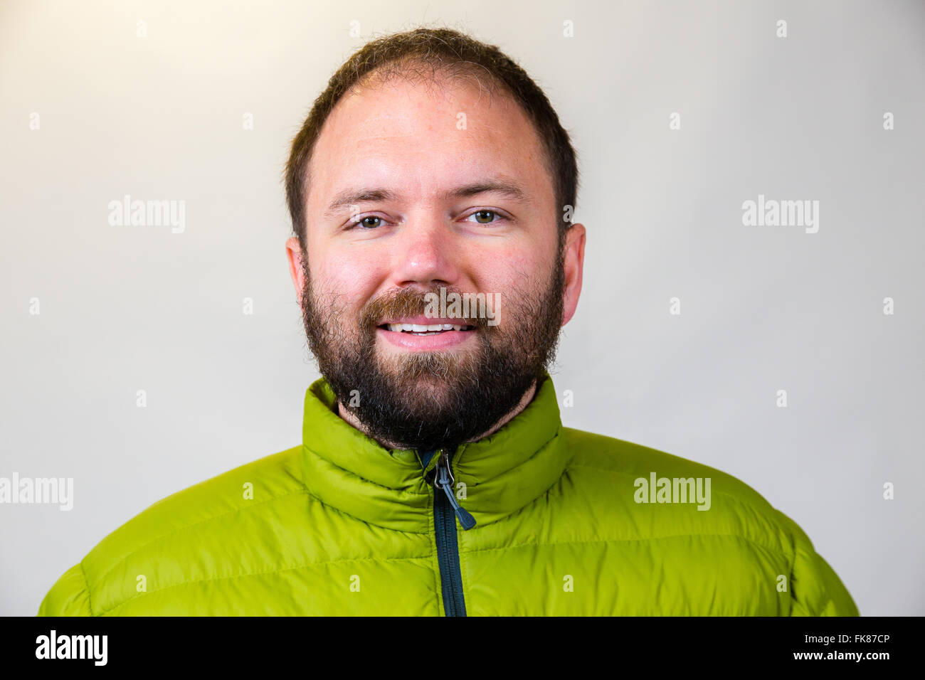 Man in his mid-30's poses for a studio portrait with a semi white ...