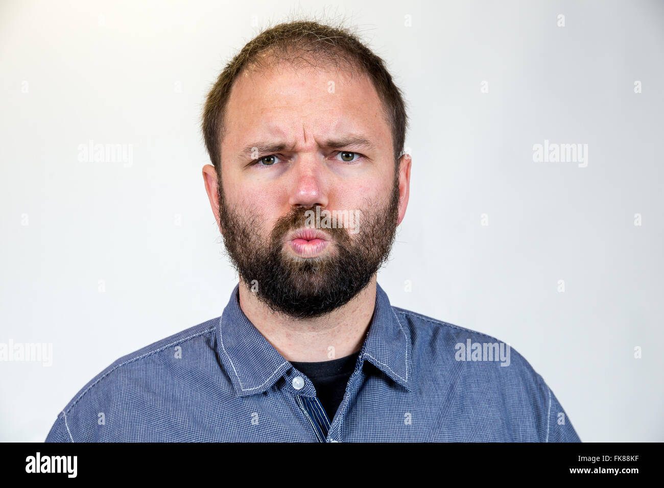 Man in his mid-30's poses for a studio portrait with a semi white ...