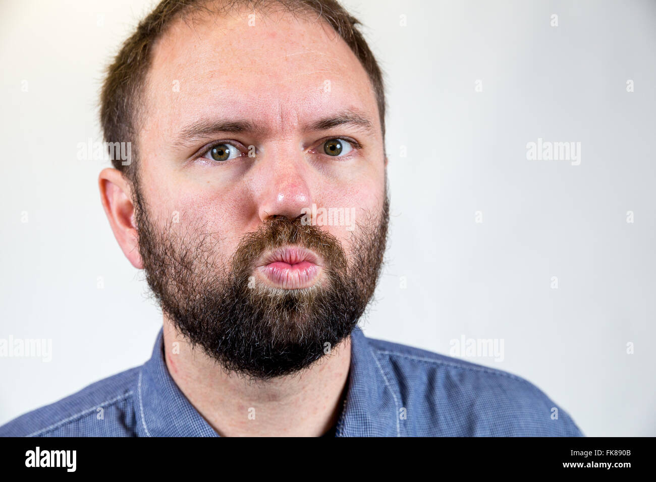 Man in his mid-30's poses for a studio portrait with a semi white ...