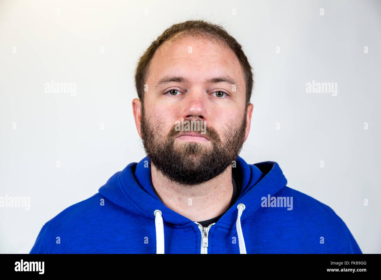 Man in his mid-30's poses for a studio portrait with a semi white ...
