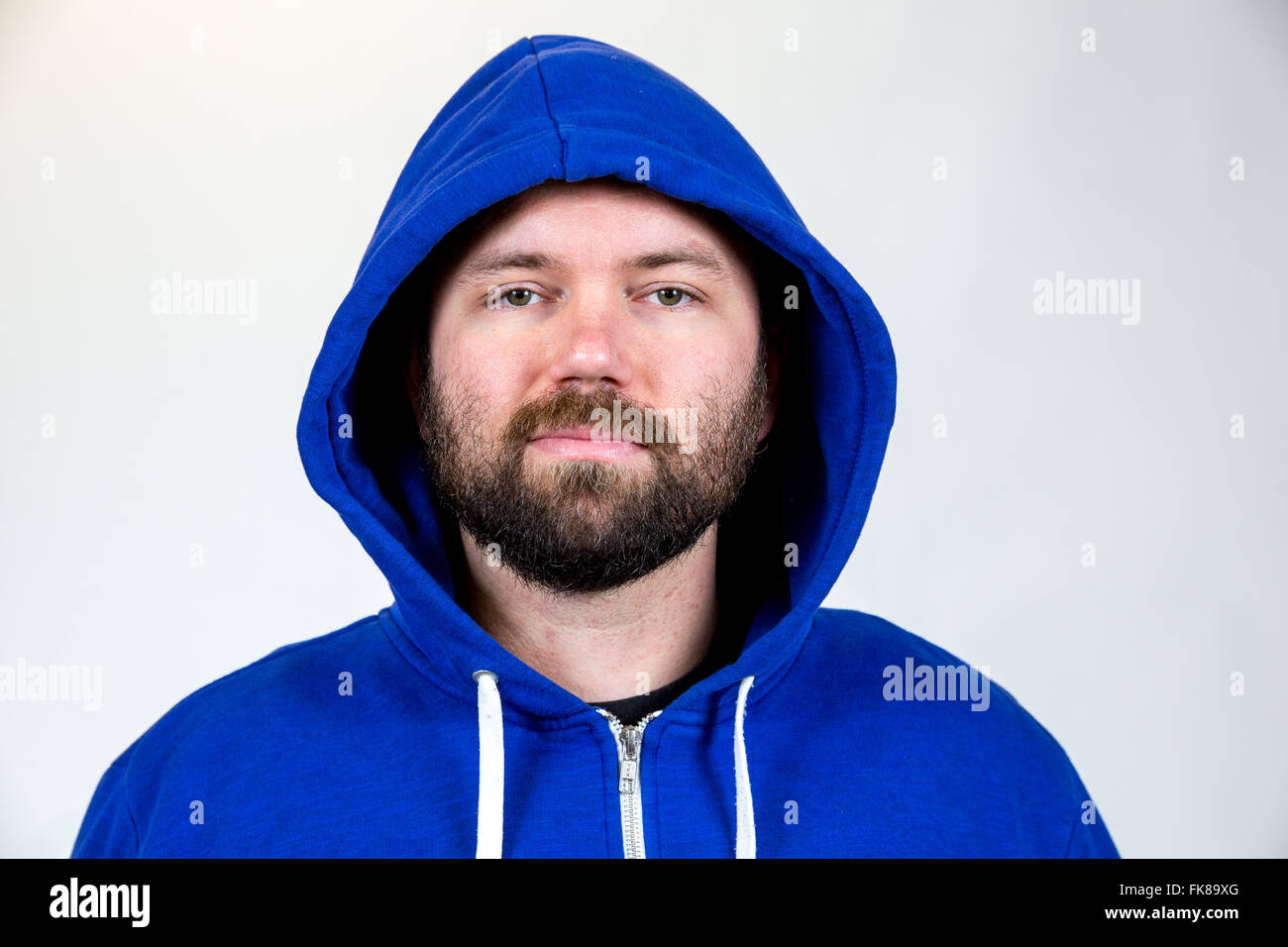 Man in his mid-30's poses for a studio portrait with a semi white ...