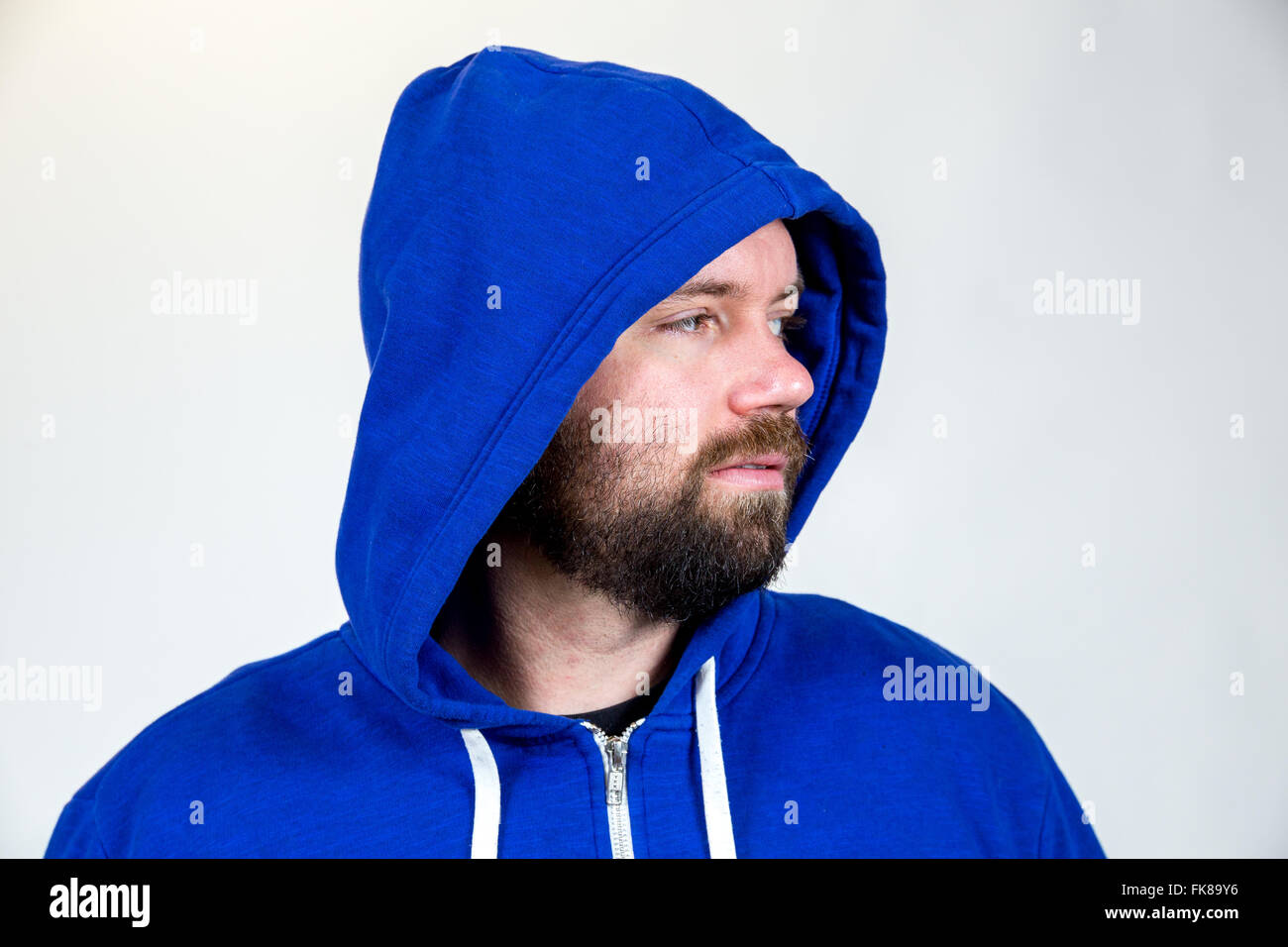 Man in his mid-30's poses for a studio portrait with a semi white ...