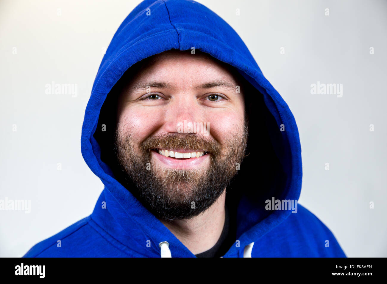 Man in his mid-30's poses for a studio portrait with a semi white ...