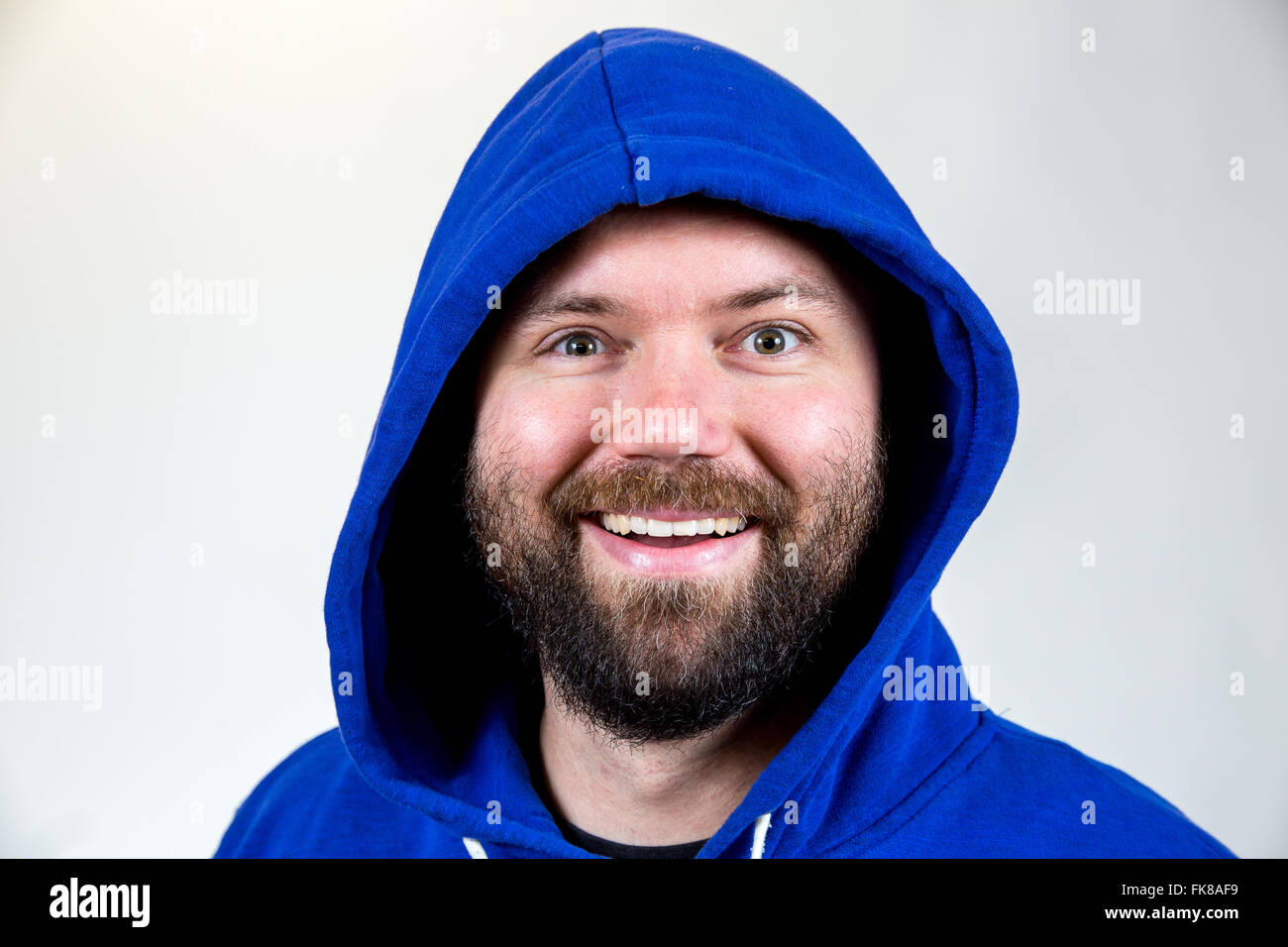 Man in his mid-30's poses for a studio portrait with a semi white ...