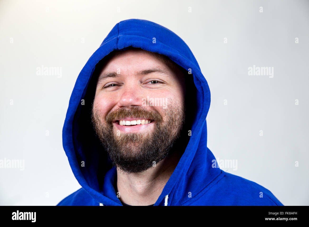 Man in his mid-30's poses for a studio portrait with a semi white ...