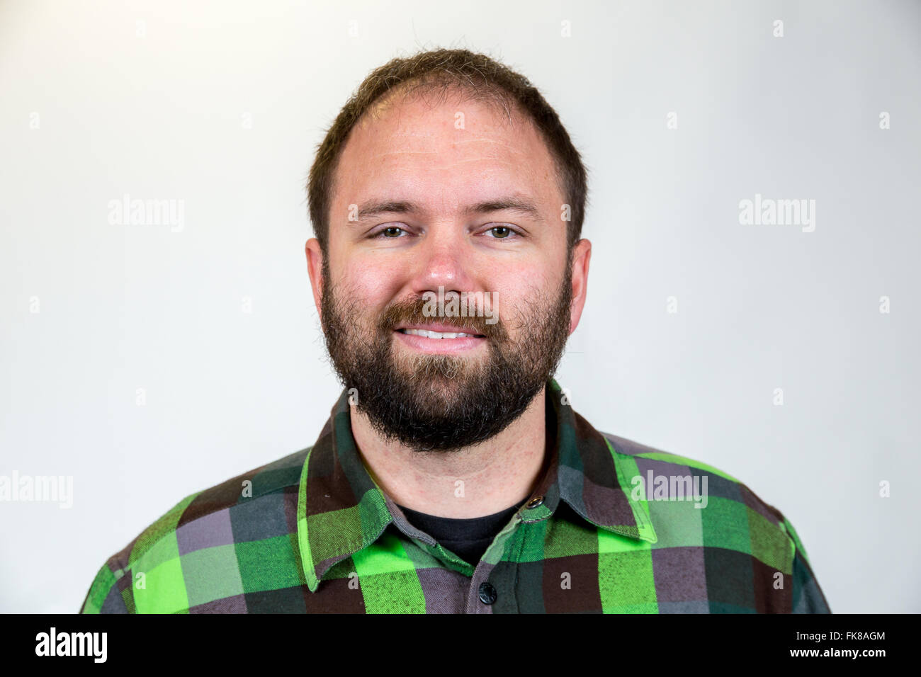 Man in his mid-30's poses for a studio portrait with a semi white ...