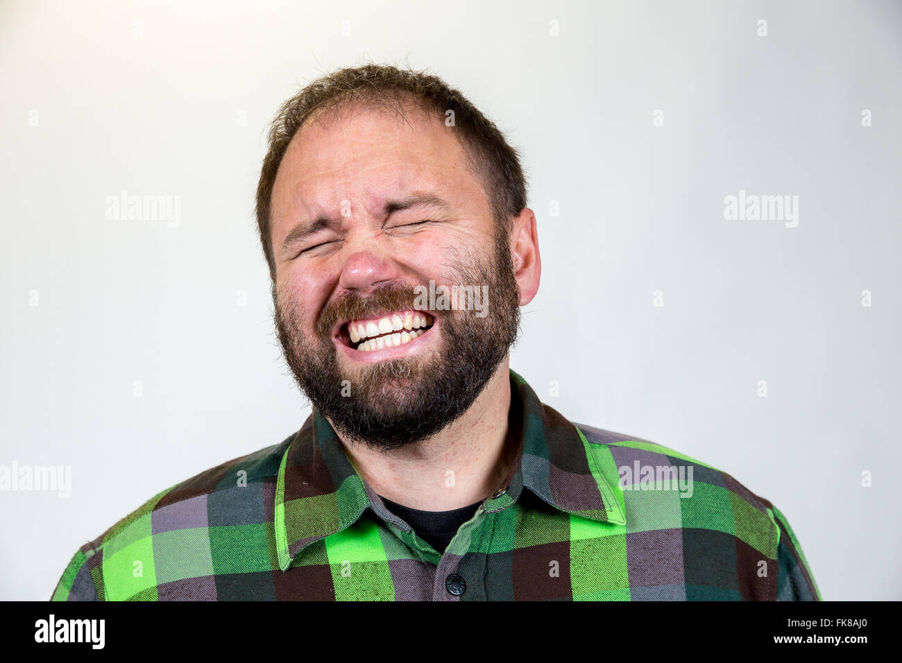 Man in his mid-30's poses for a studio portrait with a semi white ...