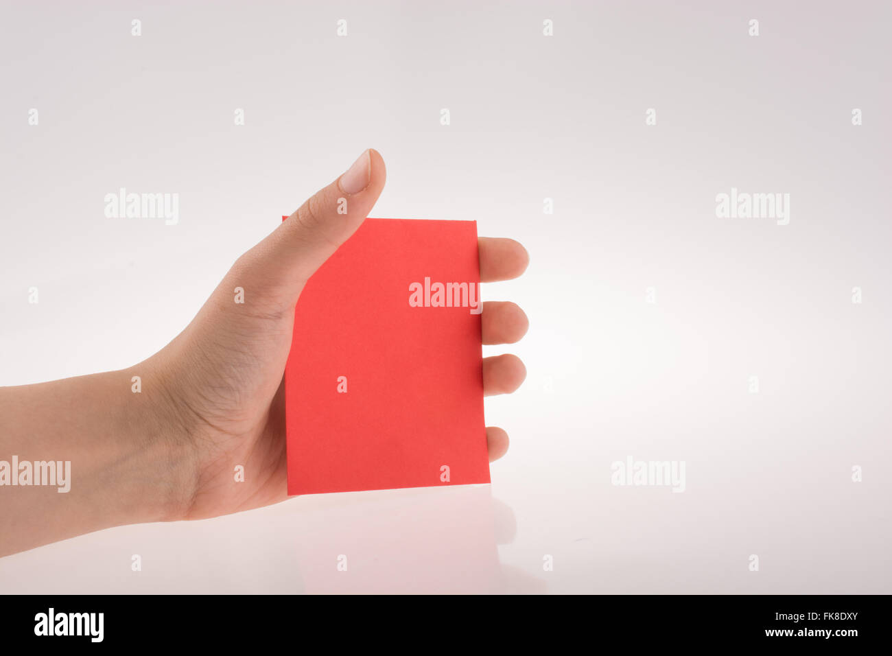hand holding a red note paper on white background Stock Photo - Alamy
