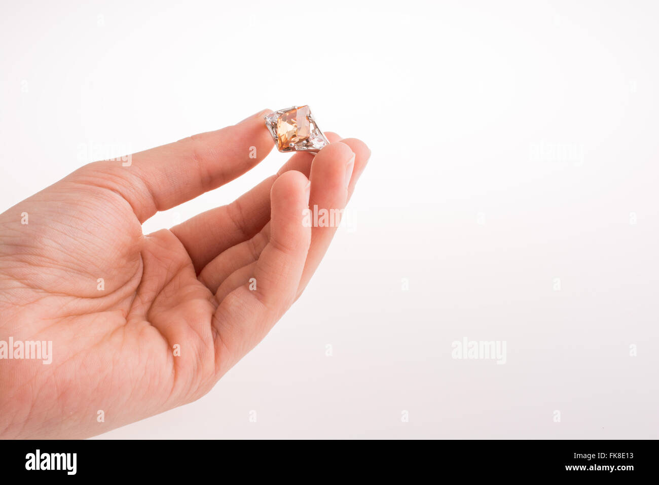 Hand holding a ring on a white background Stock Photo - Alamy