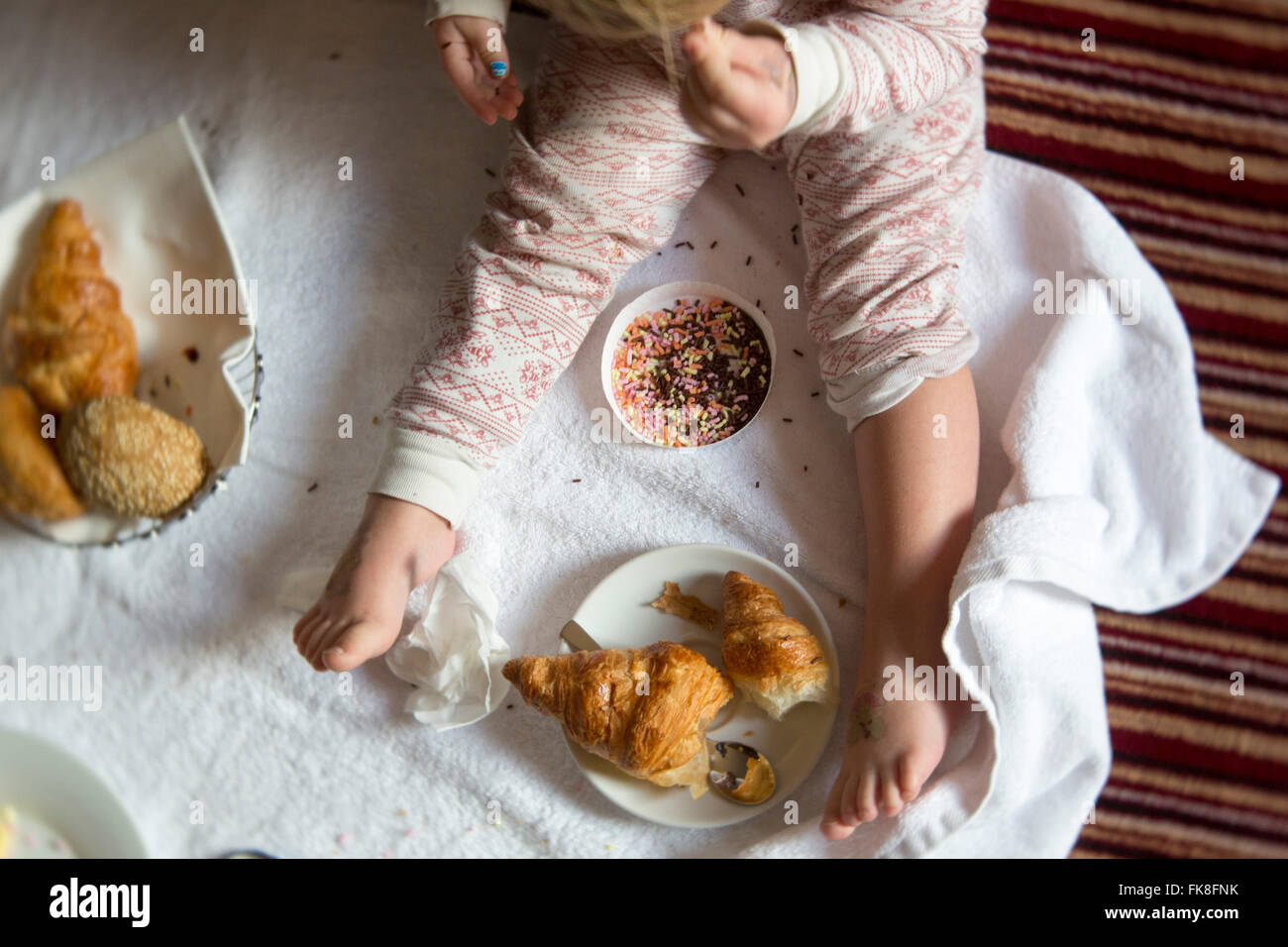 Little girl eating breakfast in pajamas on a hotel room floor Stock ...