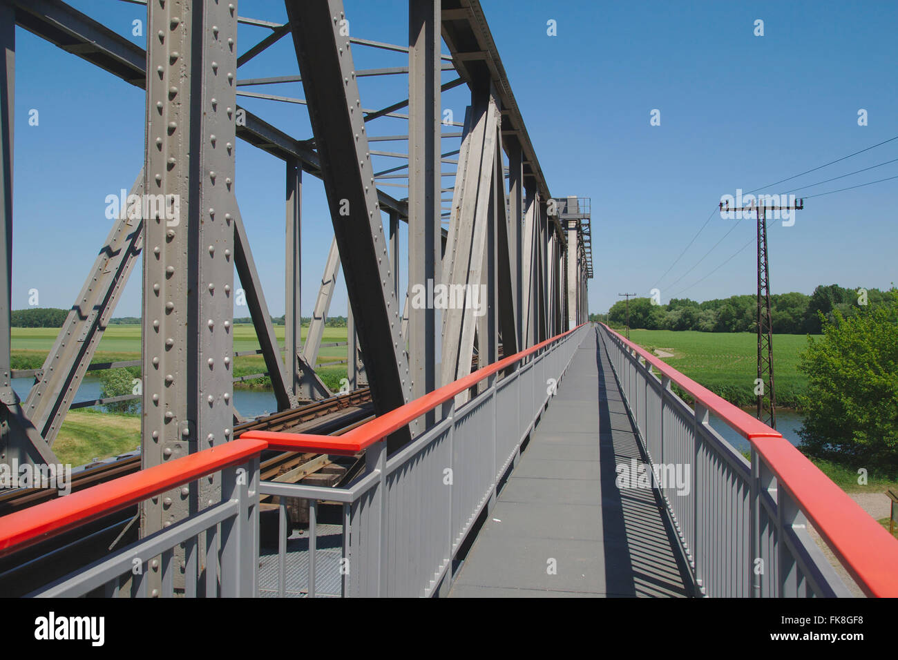 Iron truss railway bridge with red handrail, Saale river in Leuna ...