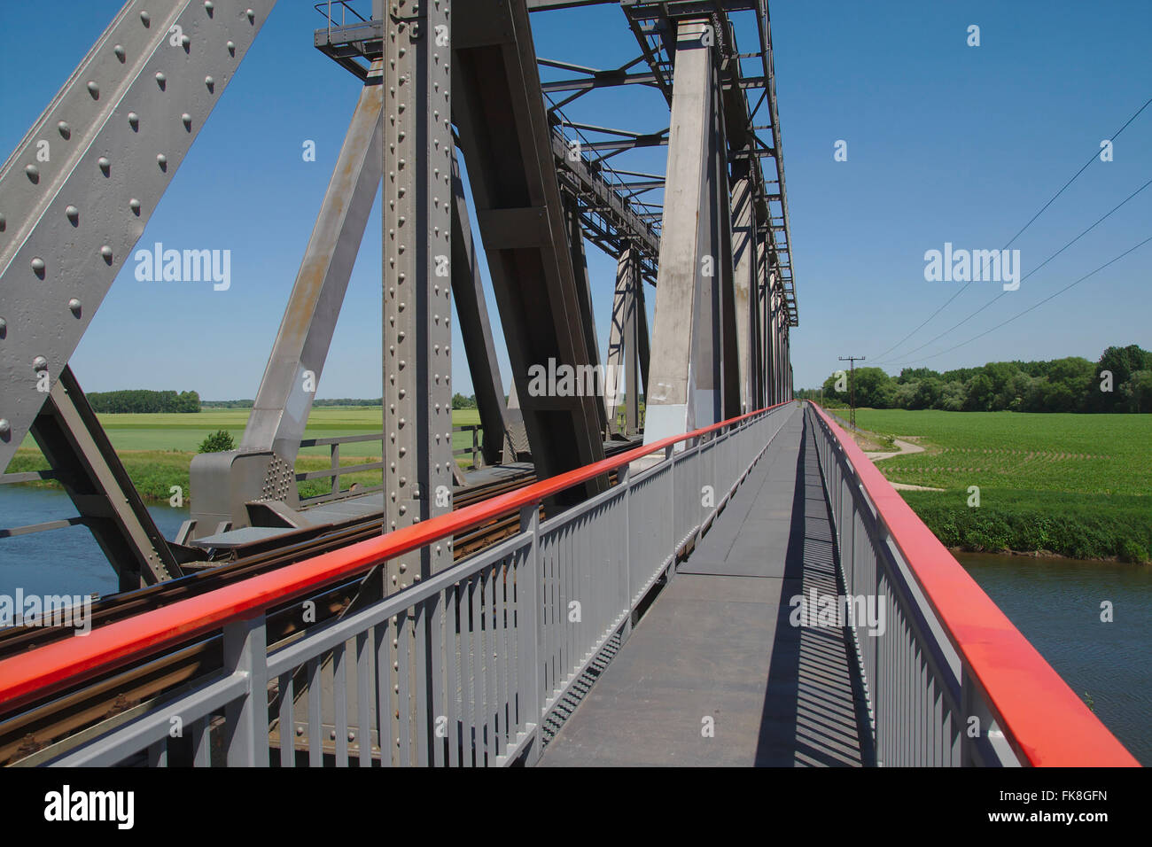 Iron truss railway bridge with red handrail, Saale river in Leuna ...