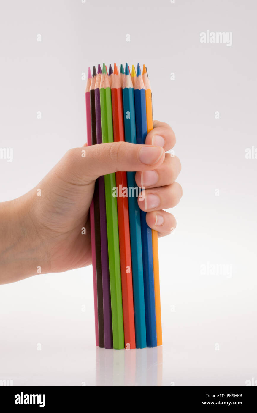 Hand holding color pencils on a white background Stock Photo - Alamy
